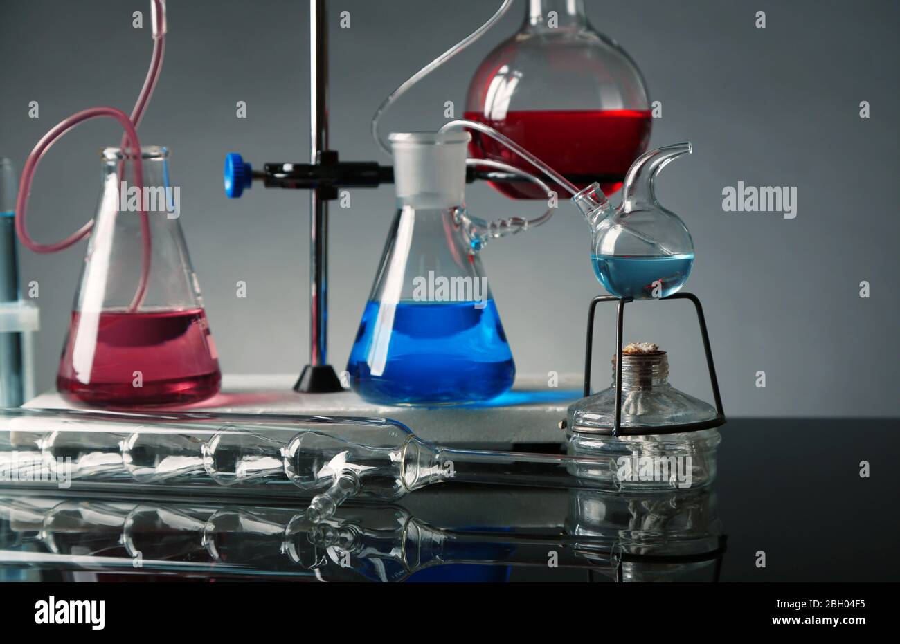 Fixed laboratory glassware on support on dark colorful background Stock ...