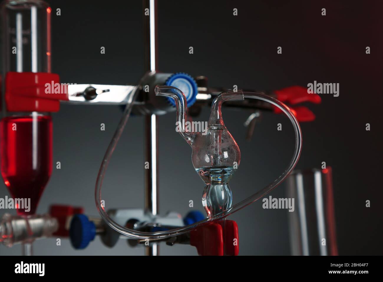 Fixed laboratory glassware on support on dark colorful background Stock ...