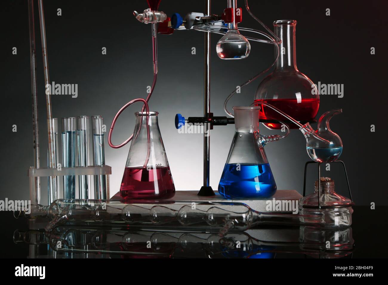Fixed laboratory glassware on support on dark colorful background Stock ...