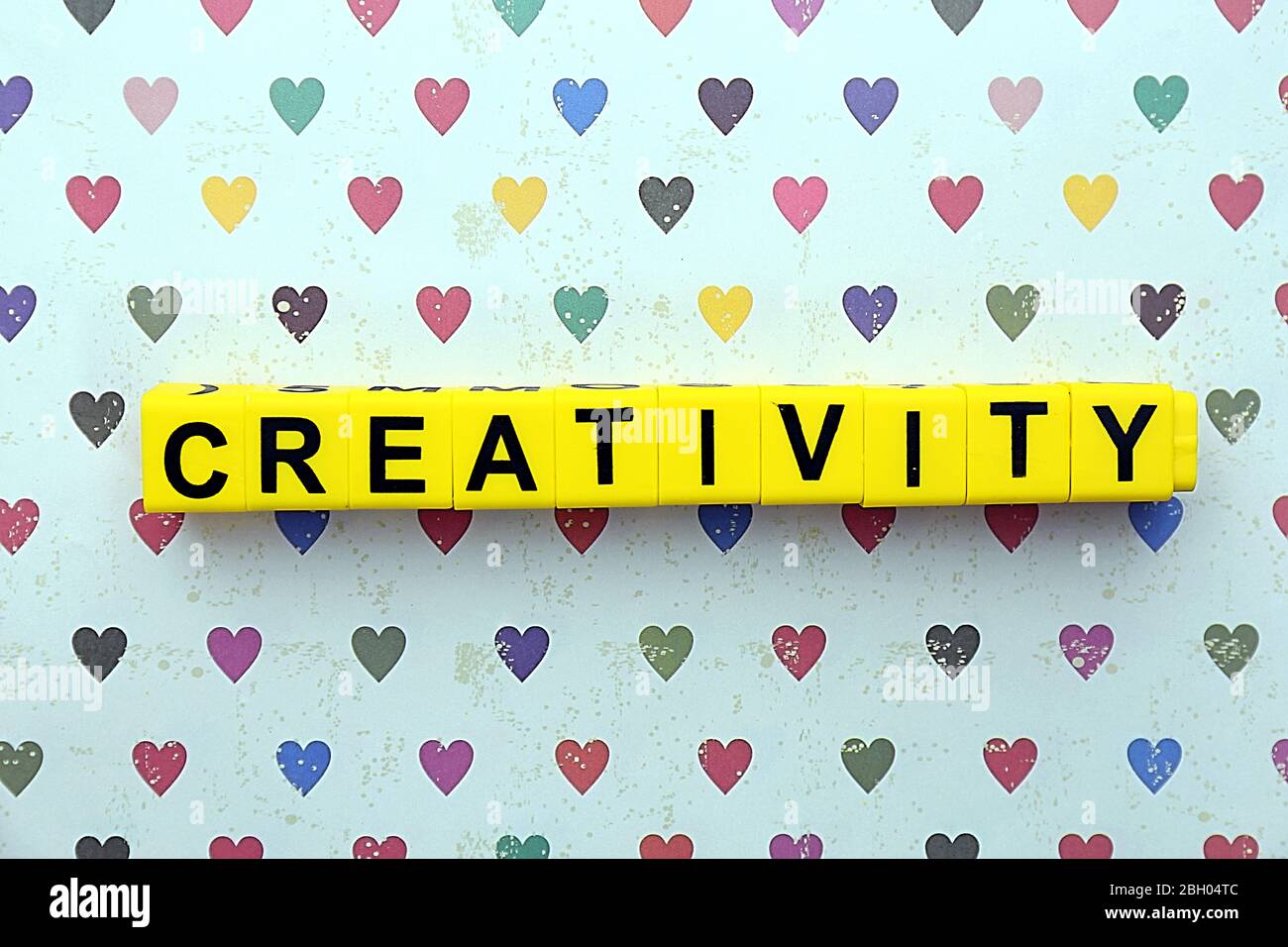 Creativity motto by alphabet letters on surface with hearts on ...