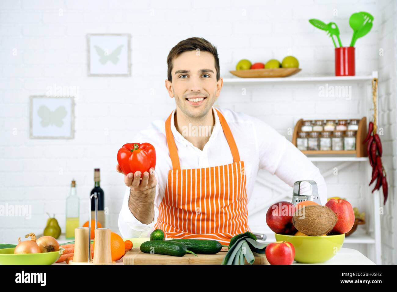 Man at table with different products and utensil in kitchen on white ...