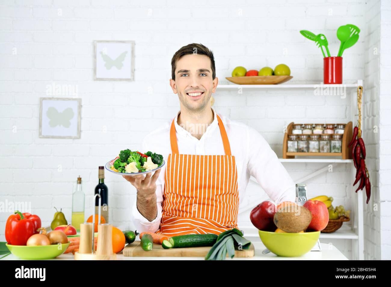 Man at table with different products and utensil in kitchen on white ...