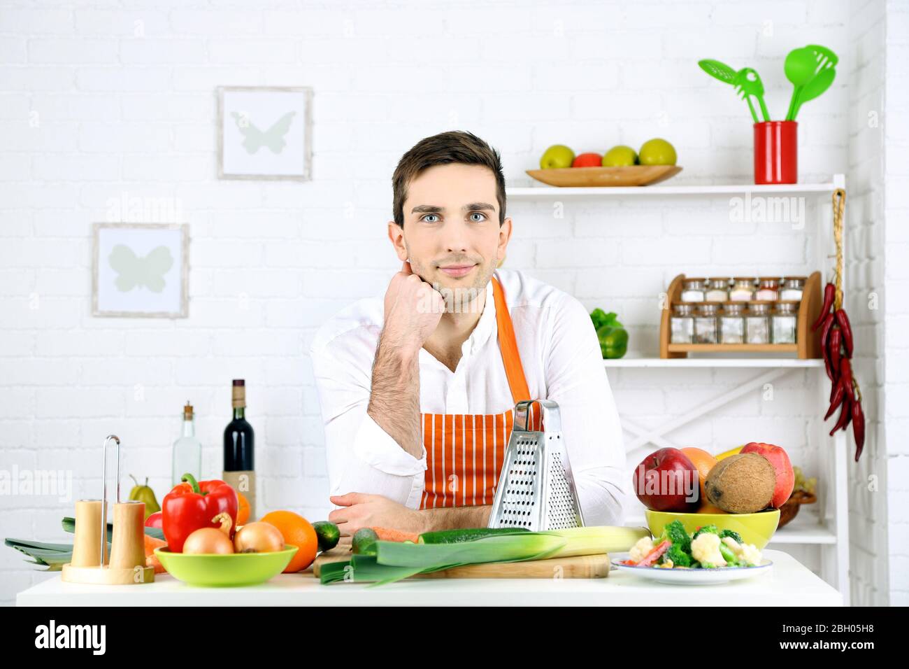 Man at table with different products and utensil in kitchen on white ...