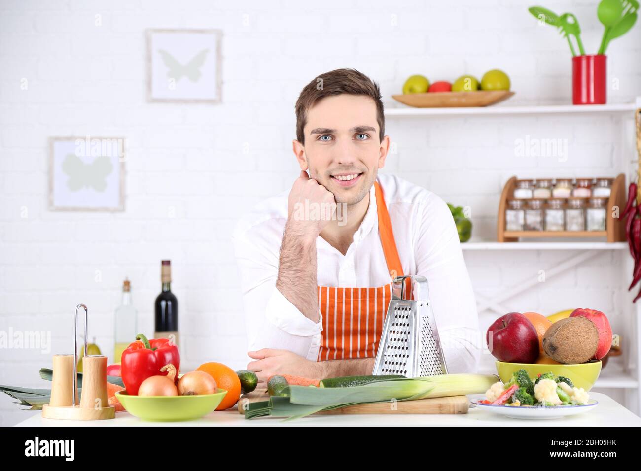 Man at table with different products and utensil in kitchen on white ...