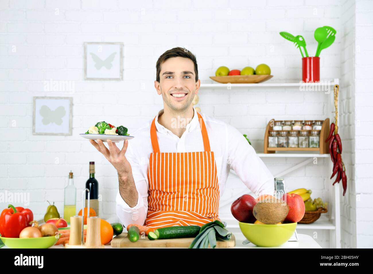 Man at table with different products and utensil in kitchen on white ...