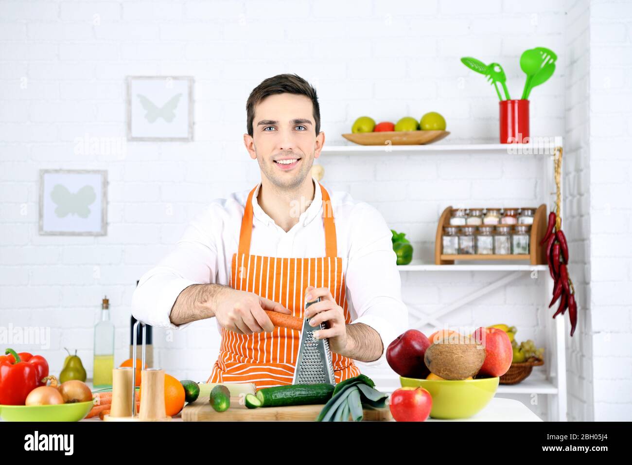 Man at table with different products and utensil in kitchen on white ...