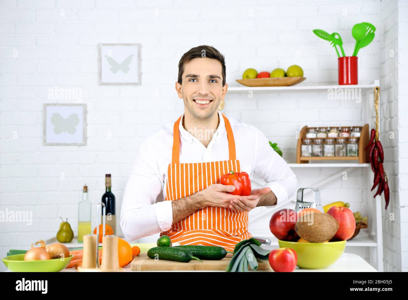 Man at table with different products and utensil in kitchen on white ...