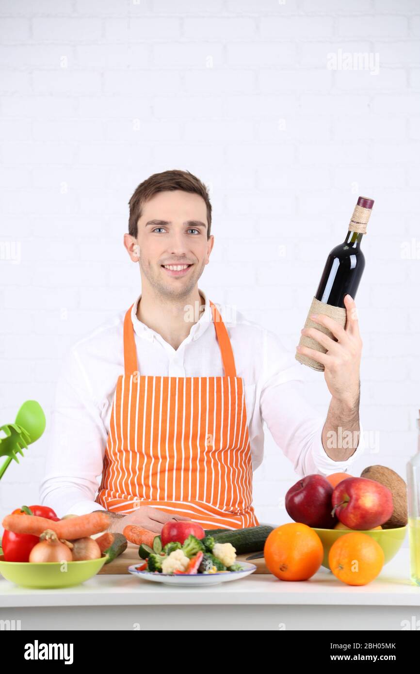 Man at table with different products and utensil in kitchen on white ...