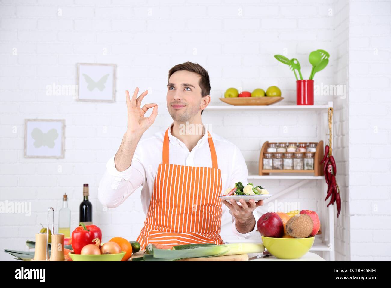 Man at table with different products and utensil in kitchen on white ...
