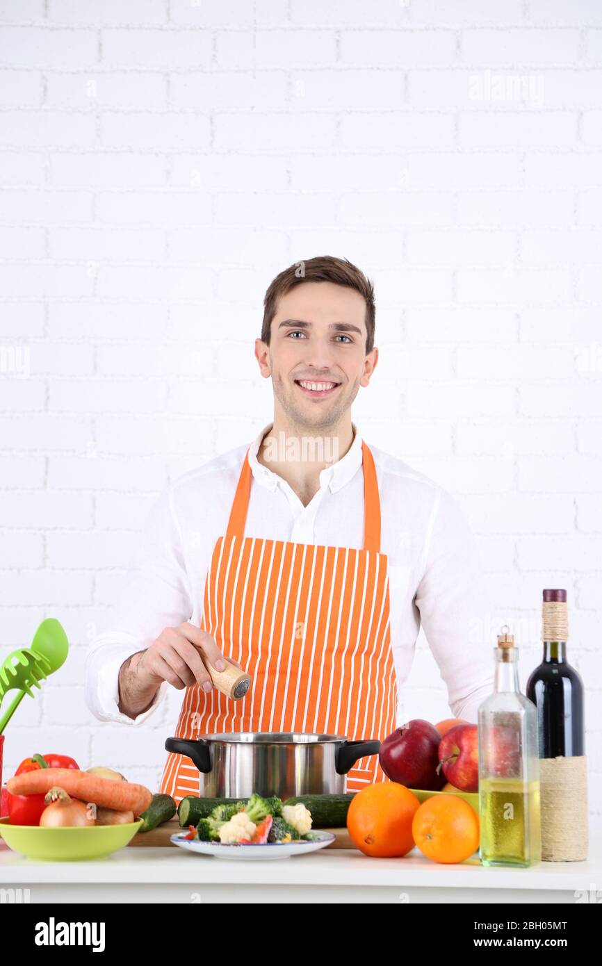 Man at table with different products and utensil in kitchen on white ...