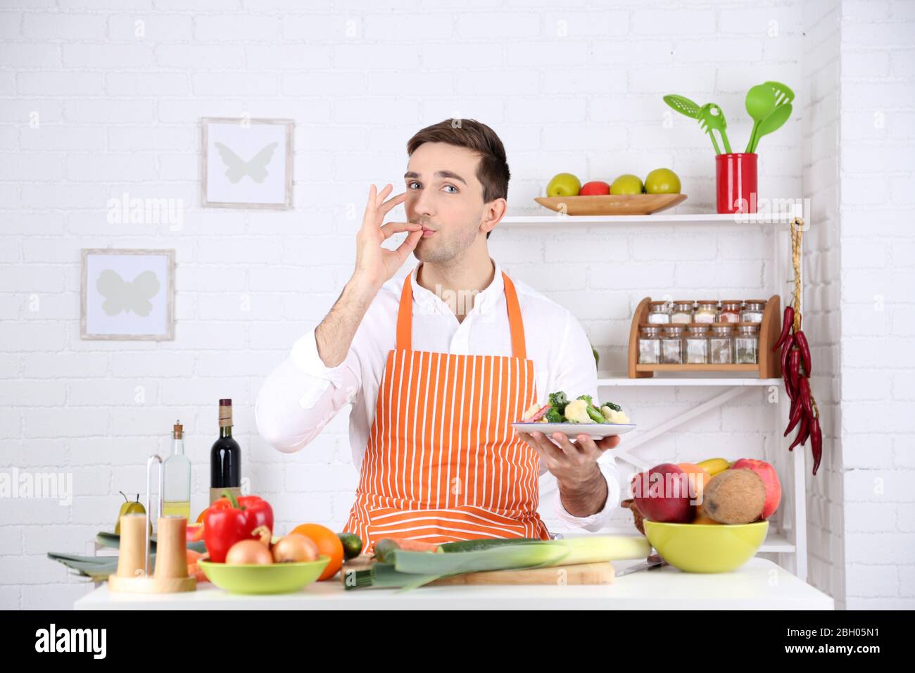 Man at table with different products and utensil in kitchen on white ...