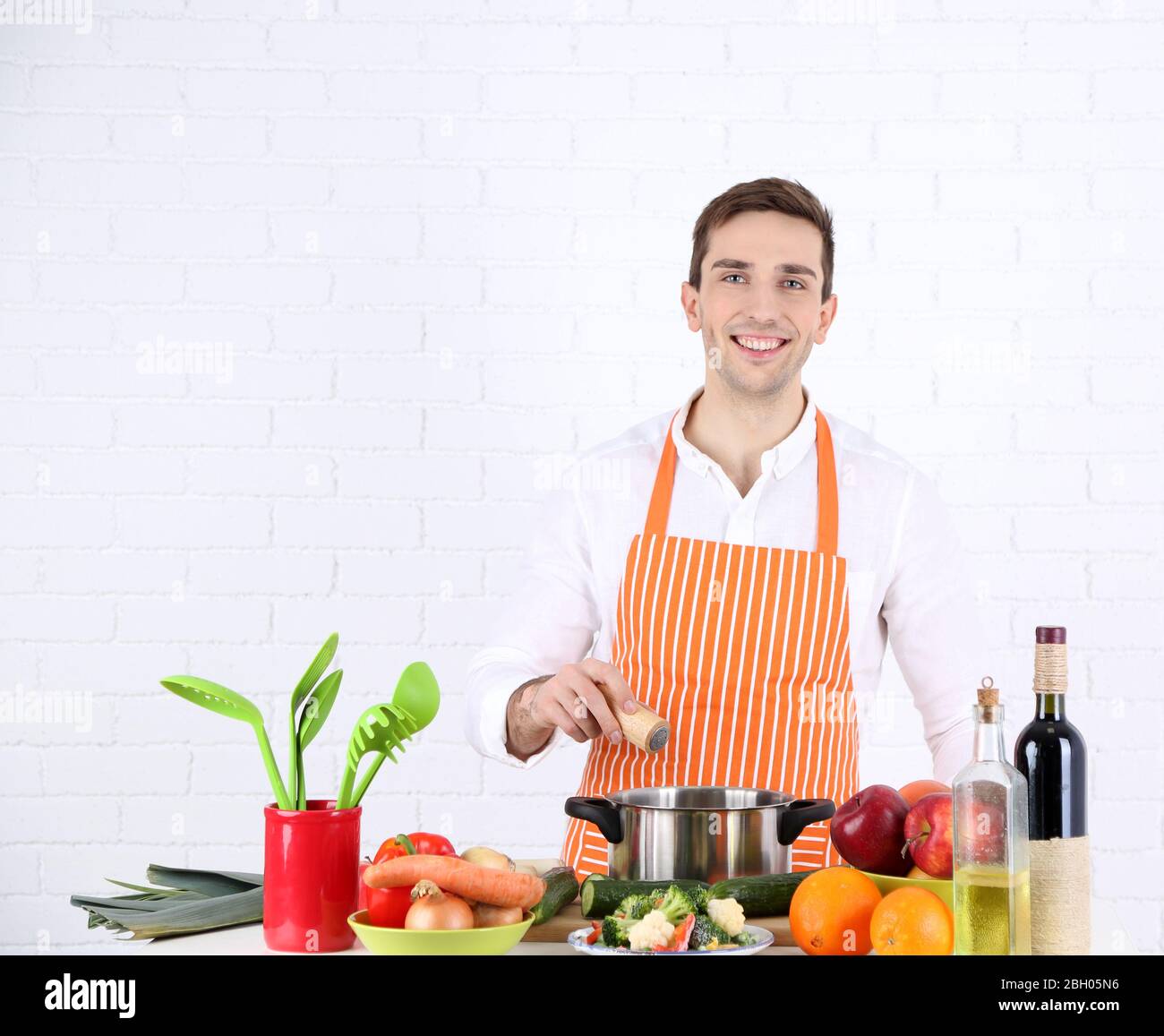 Man at table with different products and utensil in kitchen on white ...