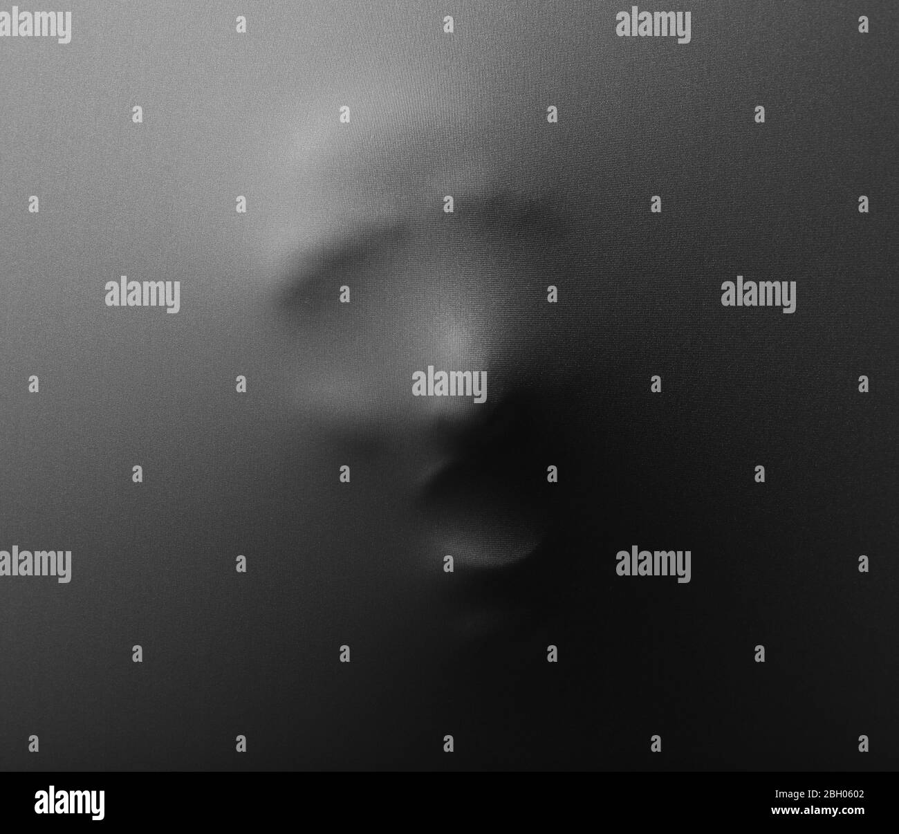 Screaming human face pressing through fabric as horror background Stock ...