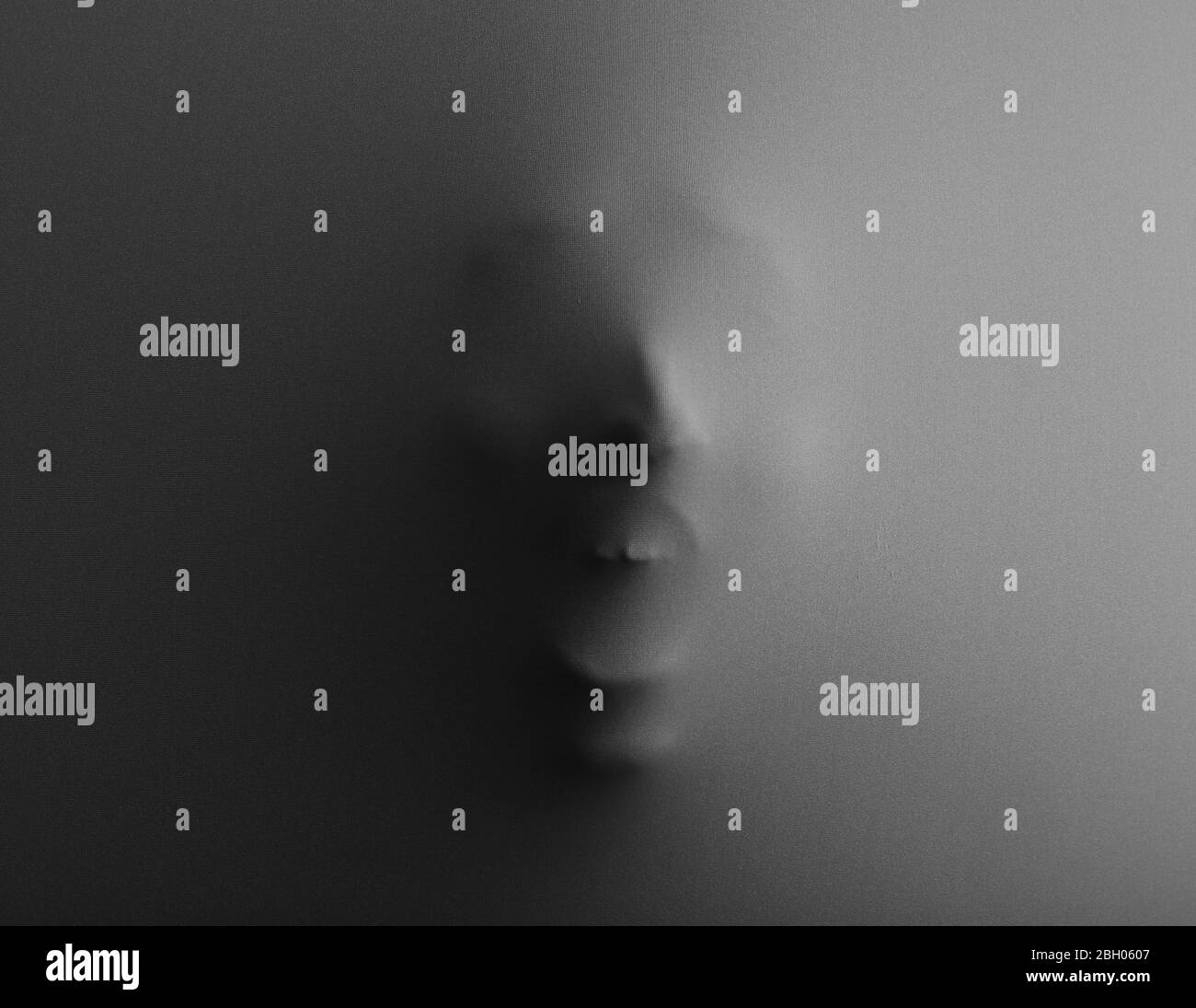 Screaming human face pressing through fabric as horror background Stock ...