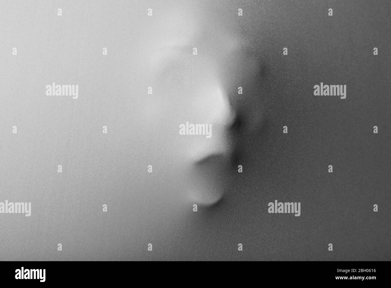 Screaming human face pressing through fabric as horror background Stock ...