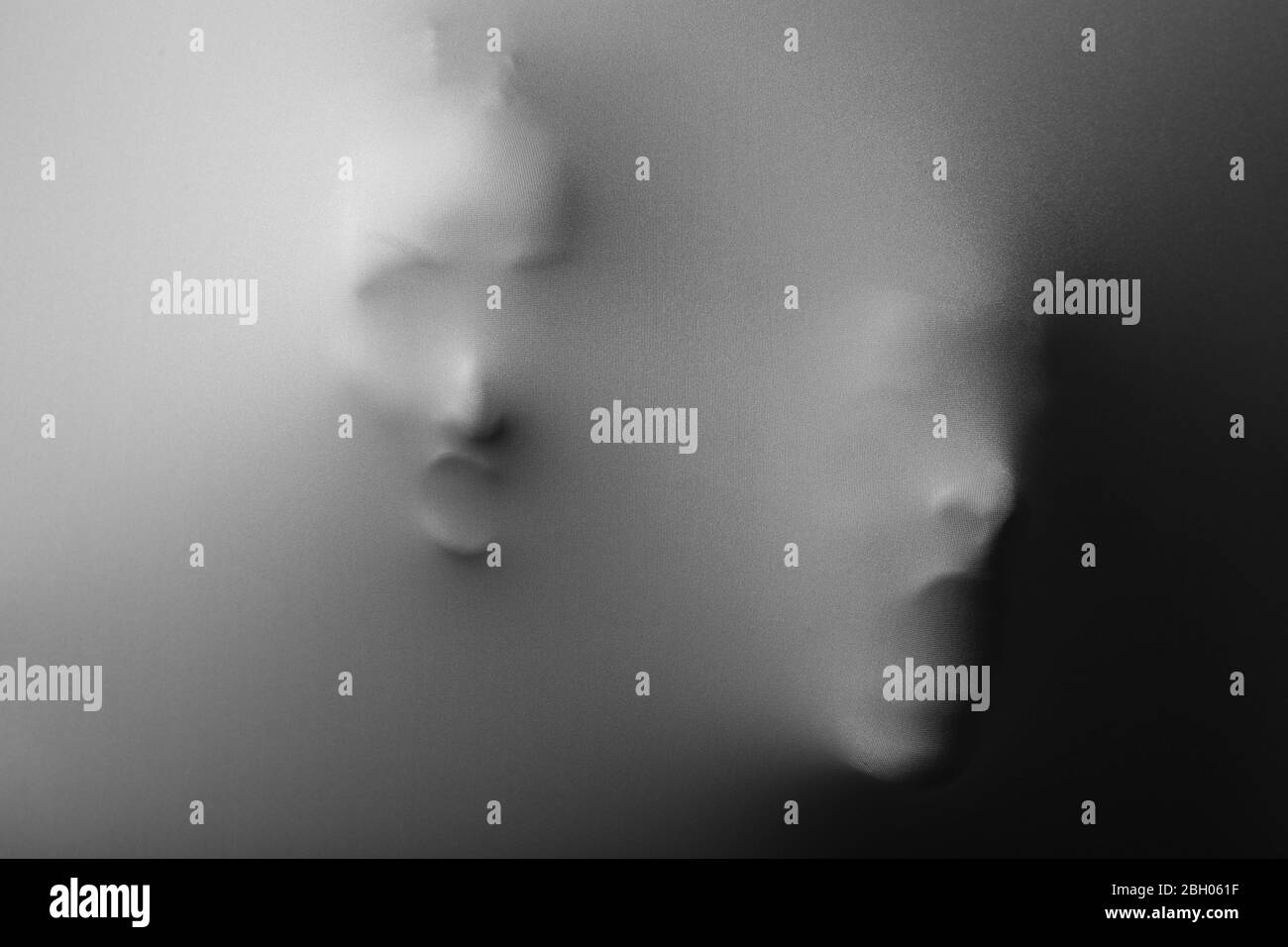 Screaming human faces pressing through fabric as horror background ...