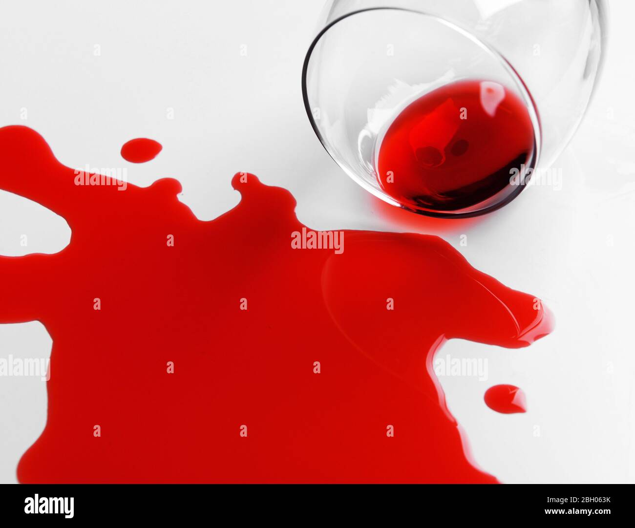 Red wine spilled from glass on white background Stock Photo - Alamy