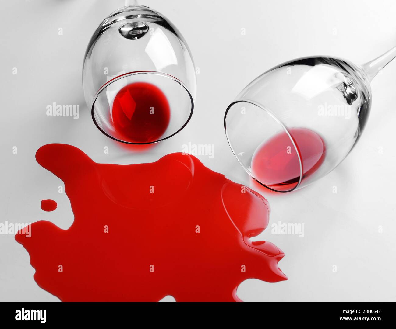 Red wine spilled from glass on white background Stock Photo - Alamy