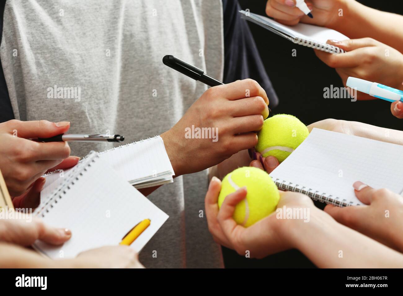 Sportsman signing autograph on tennis ball on dark background Stock ...