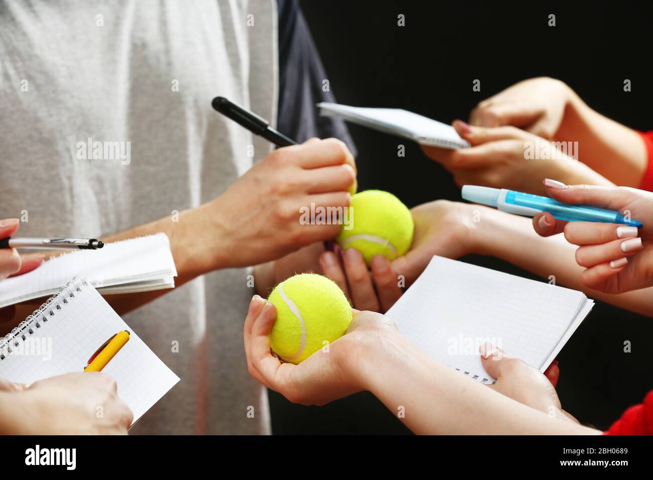 Sportsman signing autograph on tennis ball on dark background Stock ...