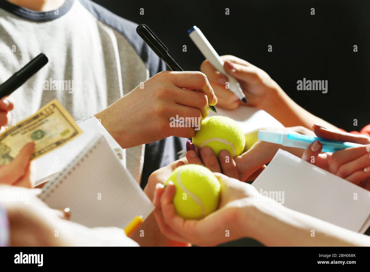 Sportsman signing autograph on tennis ball on dark background Stock ...