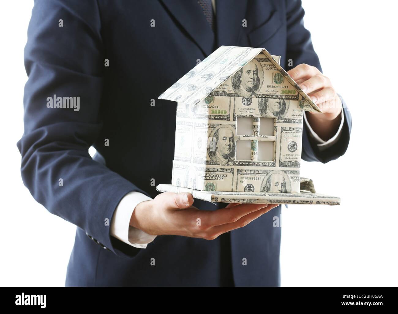 Model of house made of money in male hands isolated on white background ...
