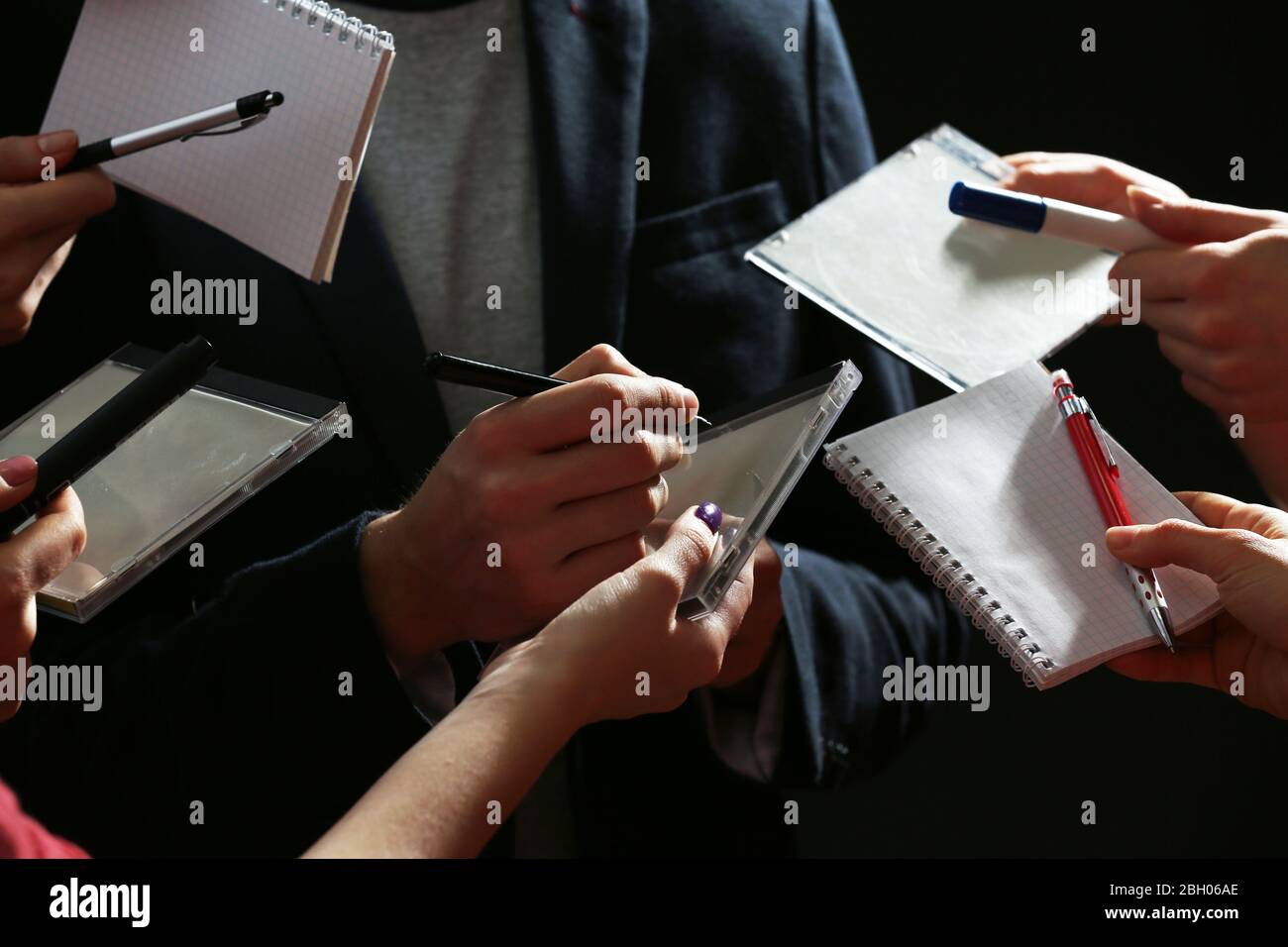 Elegant man signing autograph in notebook on dark background Stock ...