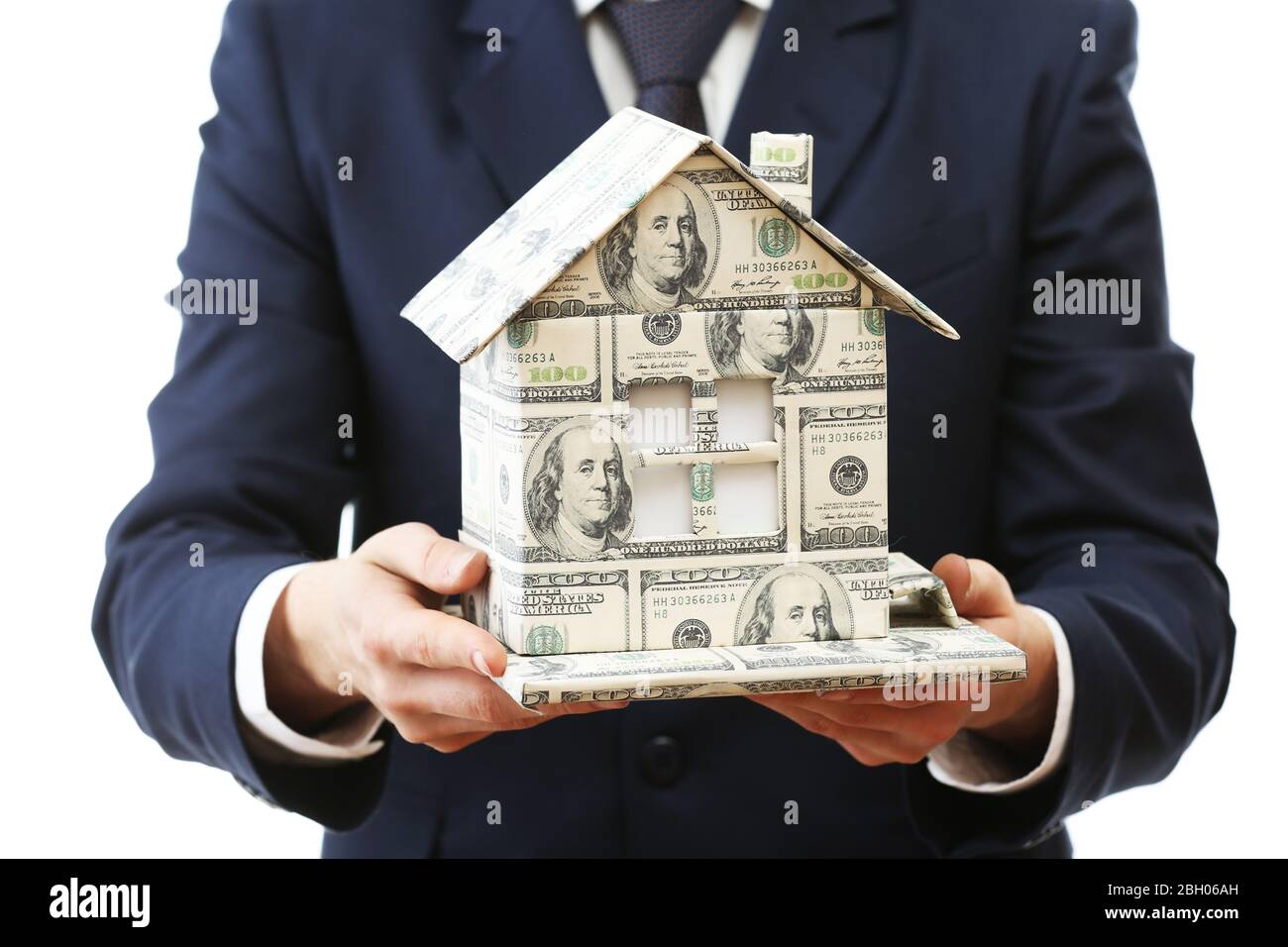 Model of house made of money in male hands isolated on white background ...