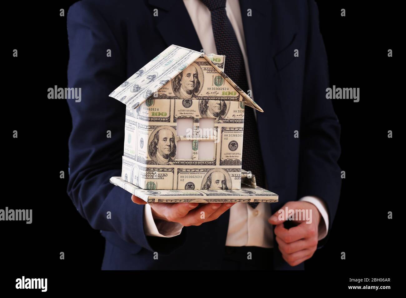 Model of house made of money in male hand on dark background Stock ...