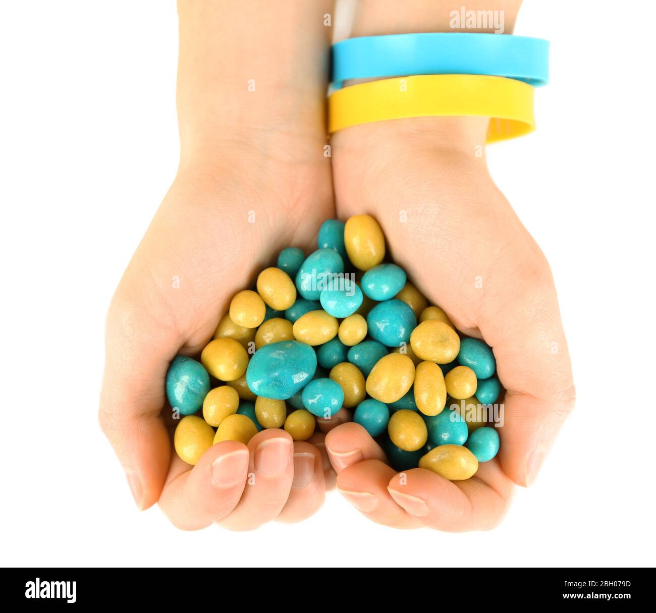Hands with blue-yellow candies - colors of flag of Ukraine, isolated on ...