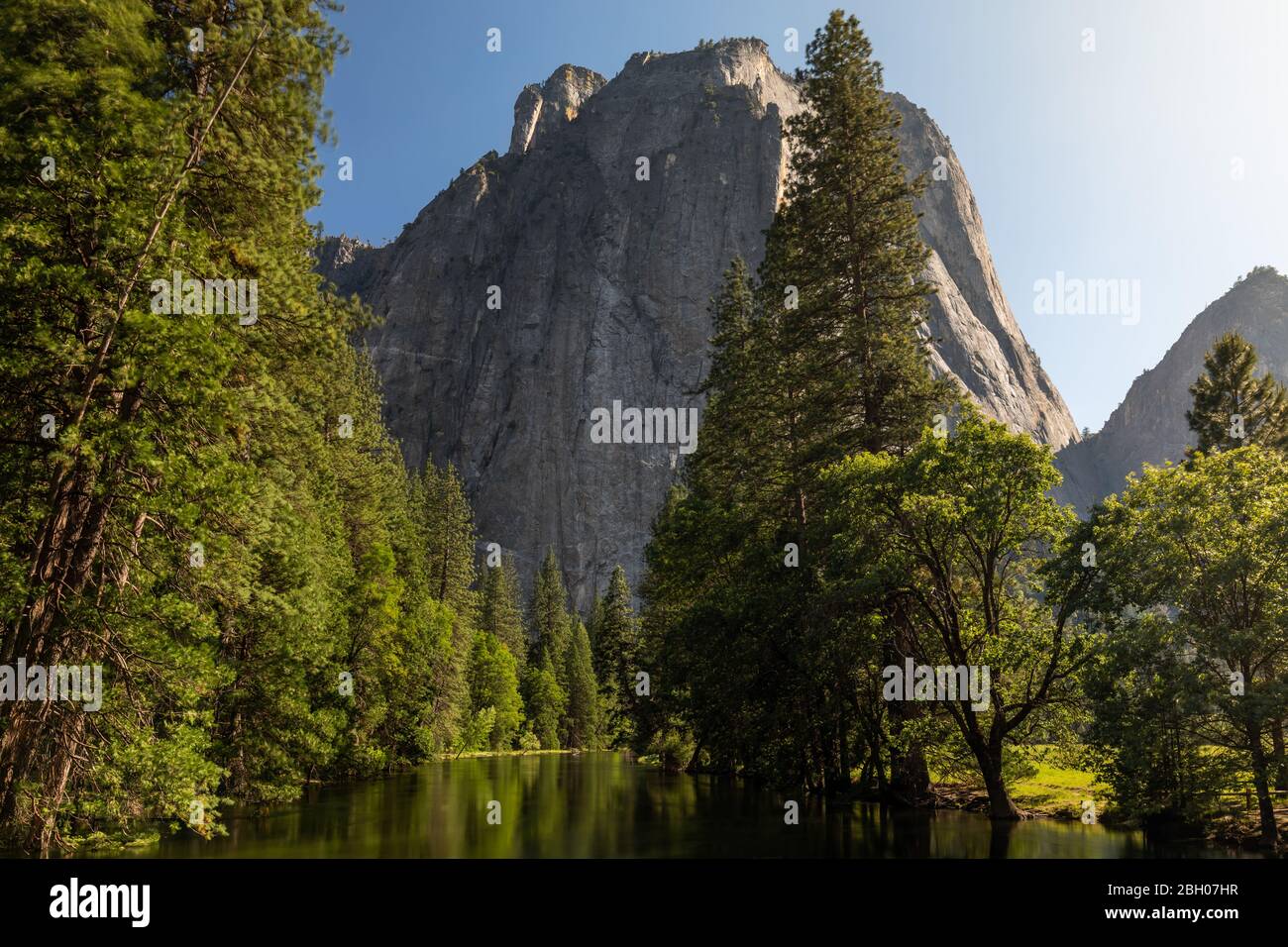A scenic view of Yosemite Valley, with a stream running among trees and ...