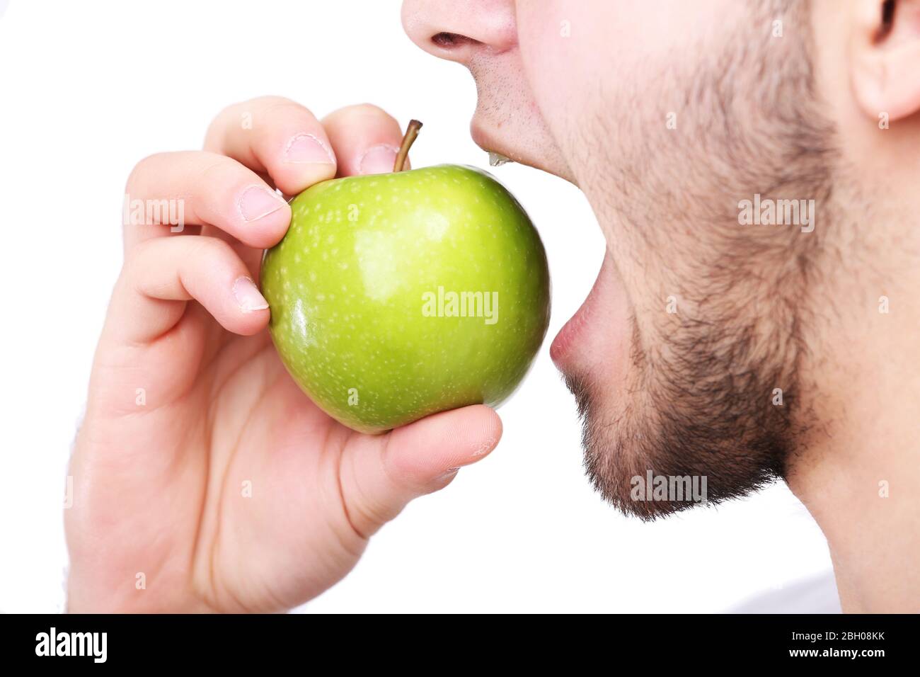 Man biting fresh green apple with healthy teeth isolated on white ...