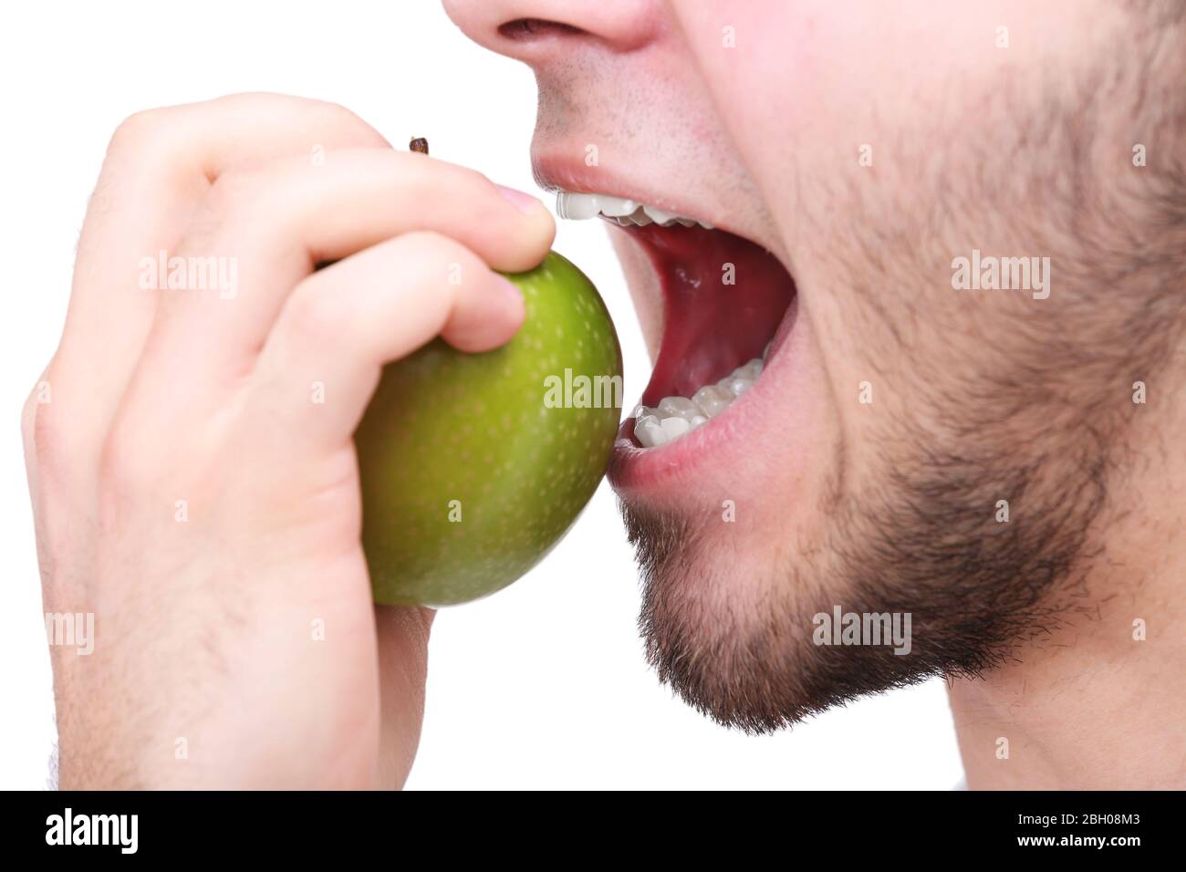 Man biting fresh green apple with healthy teeth isolated on white ...