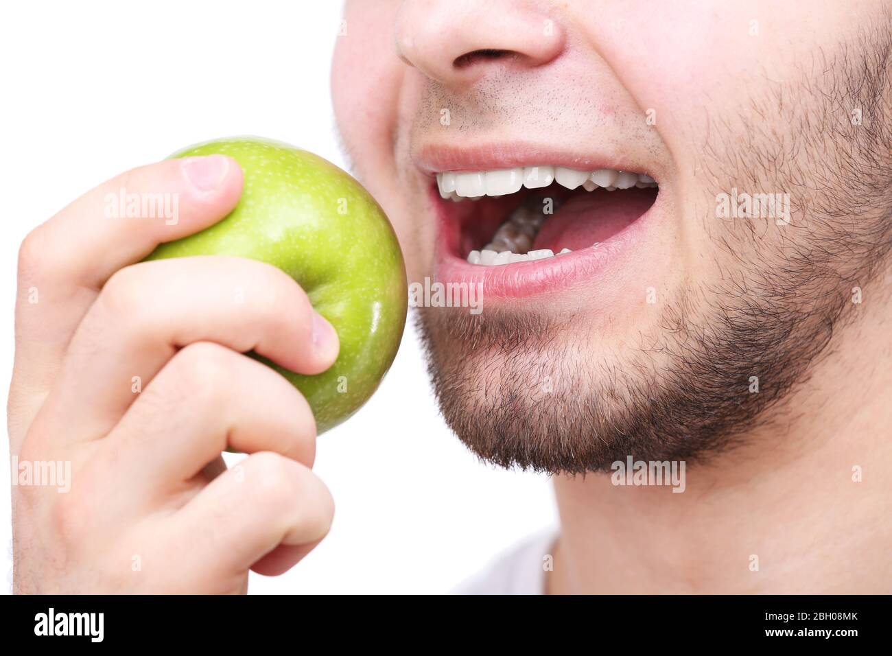 Man biting fresh green apple with healthy teeth isolated on white ...