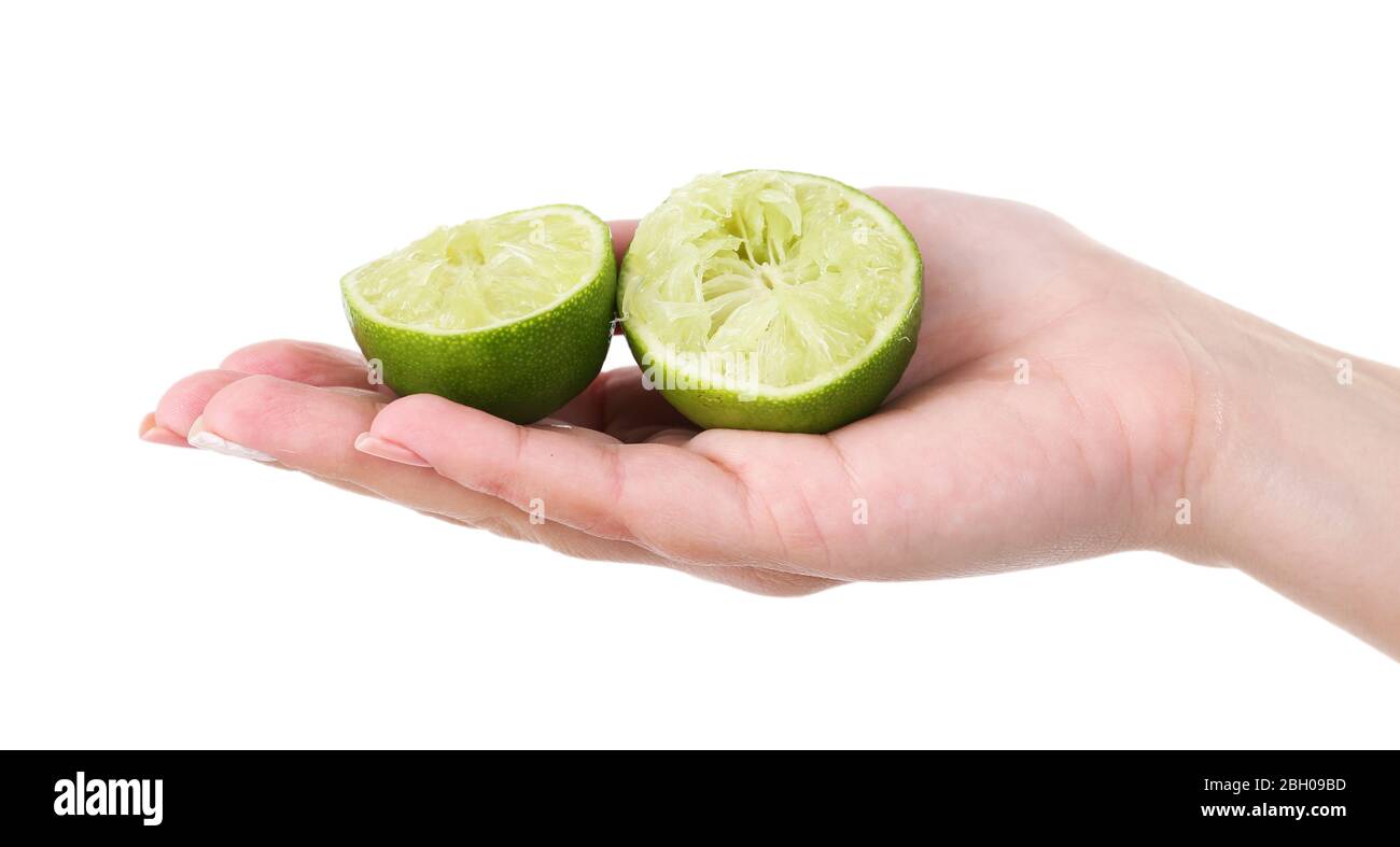Female hand holding two pieces of lime isolated on white Stock Photo ...