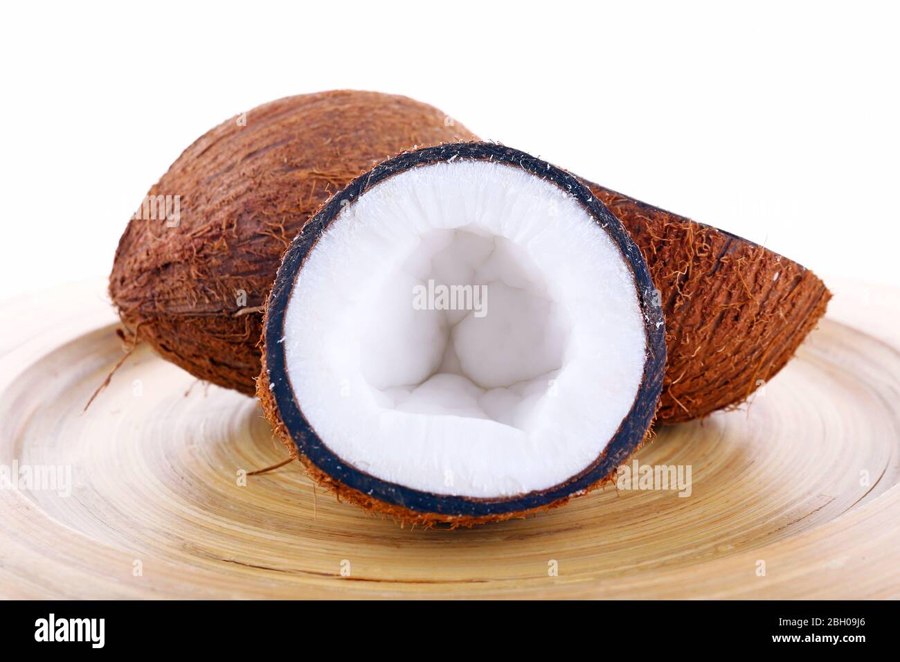 Coconut cut in half isolated on white background Stock Photo - Alamy