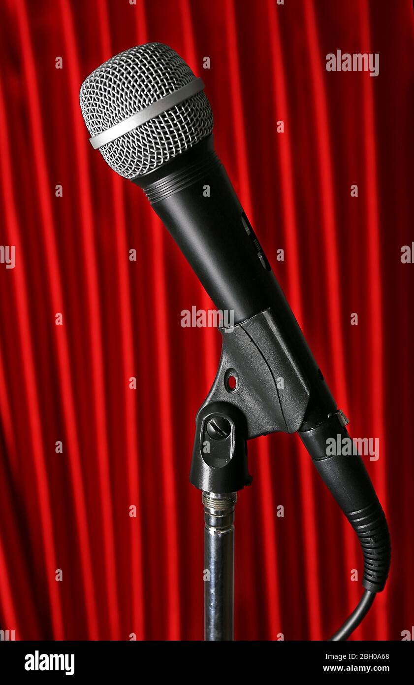 Microphone on stand on red curtain background Stock Photo - Alamy