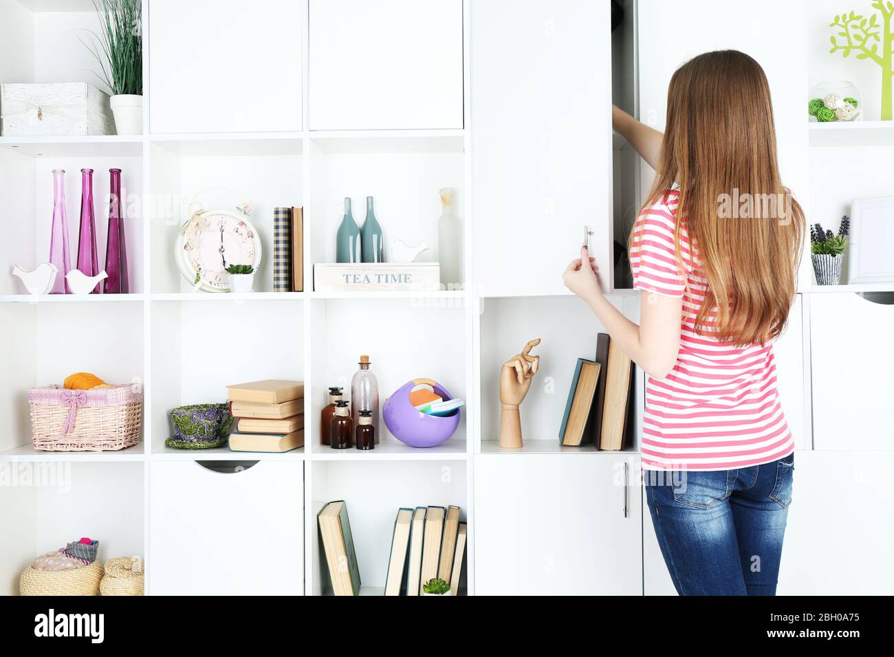 Woman looking for something in closet, in room with modern interior ...