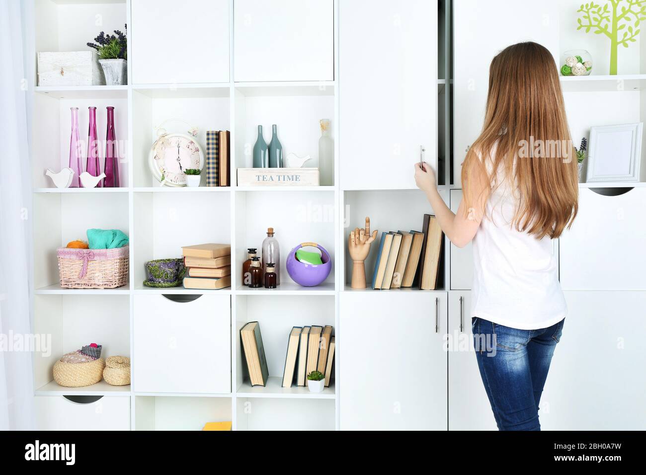 Woman looking for something in closet, in room with modern interior ...