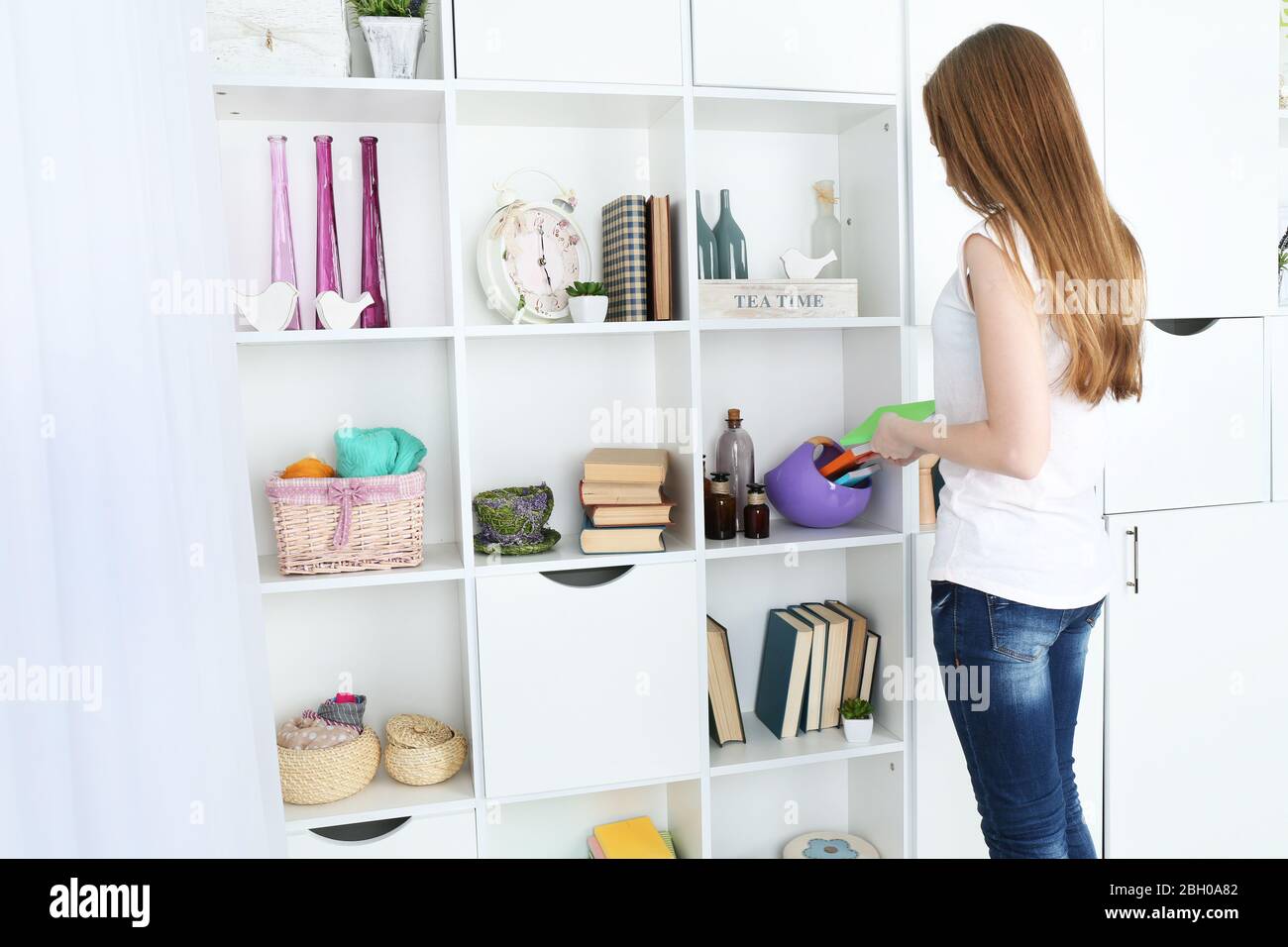 Woman looking for something in closet, in room with modern interior ...