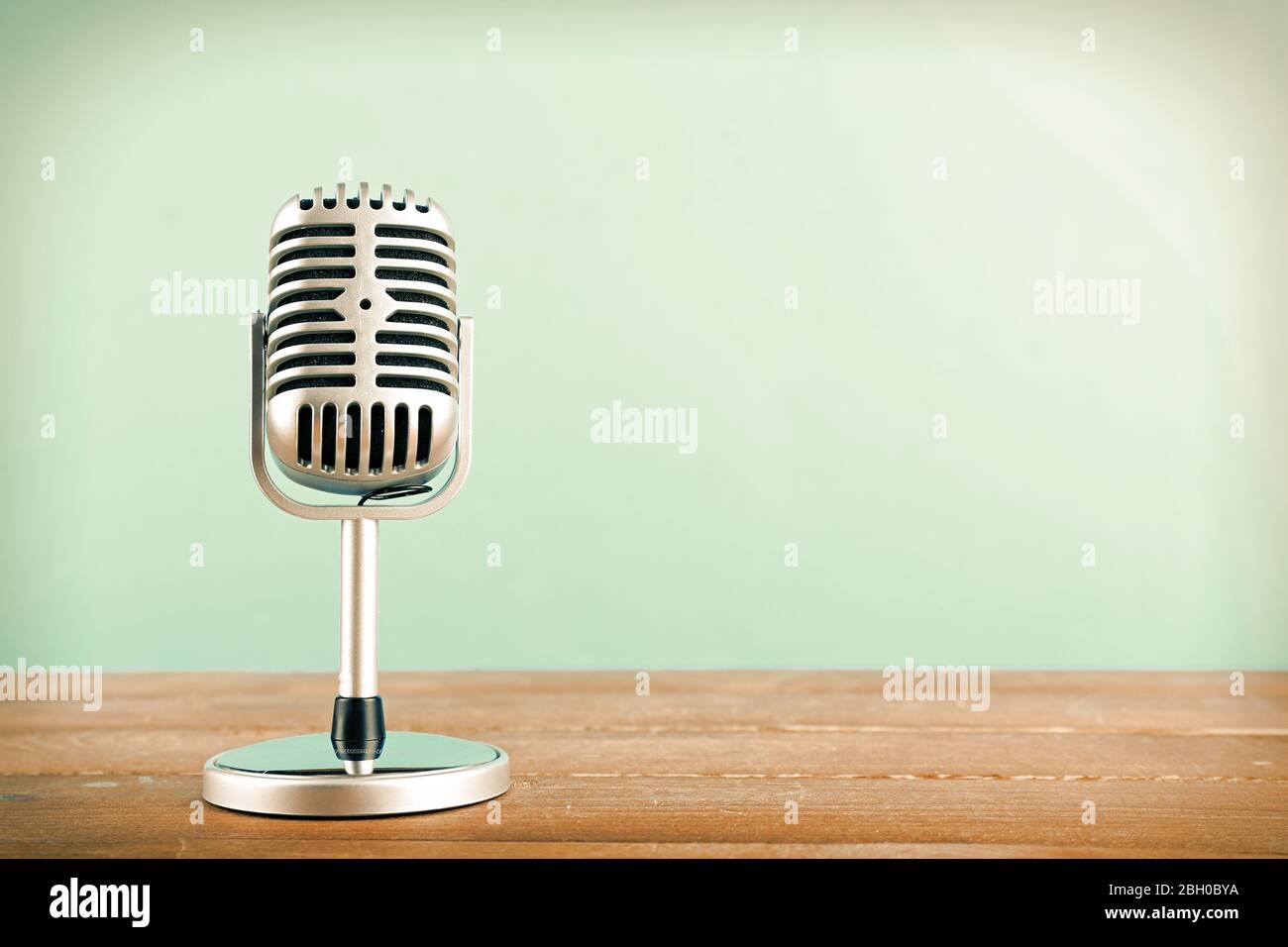 Retro microphone on wooden table on blue background Stock Photo - Alamy