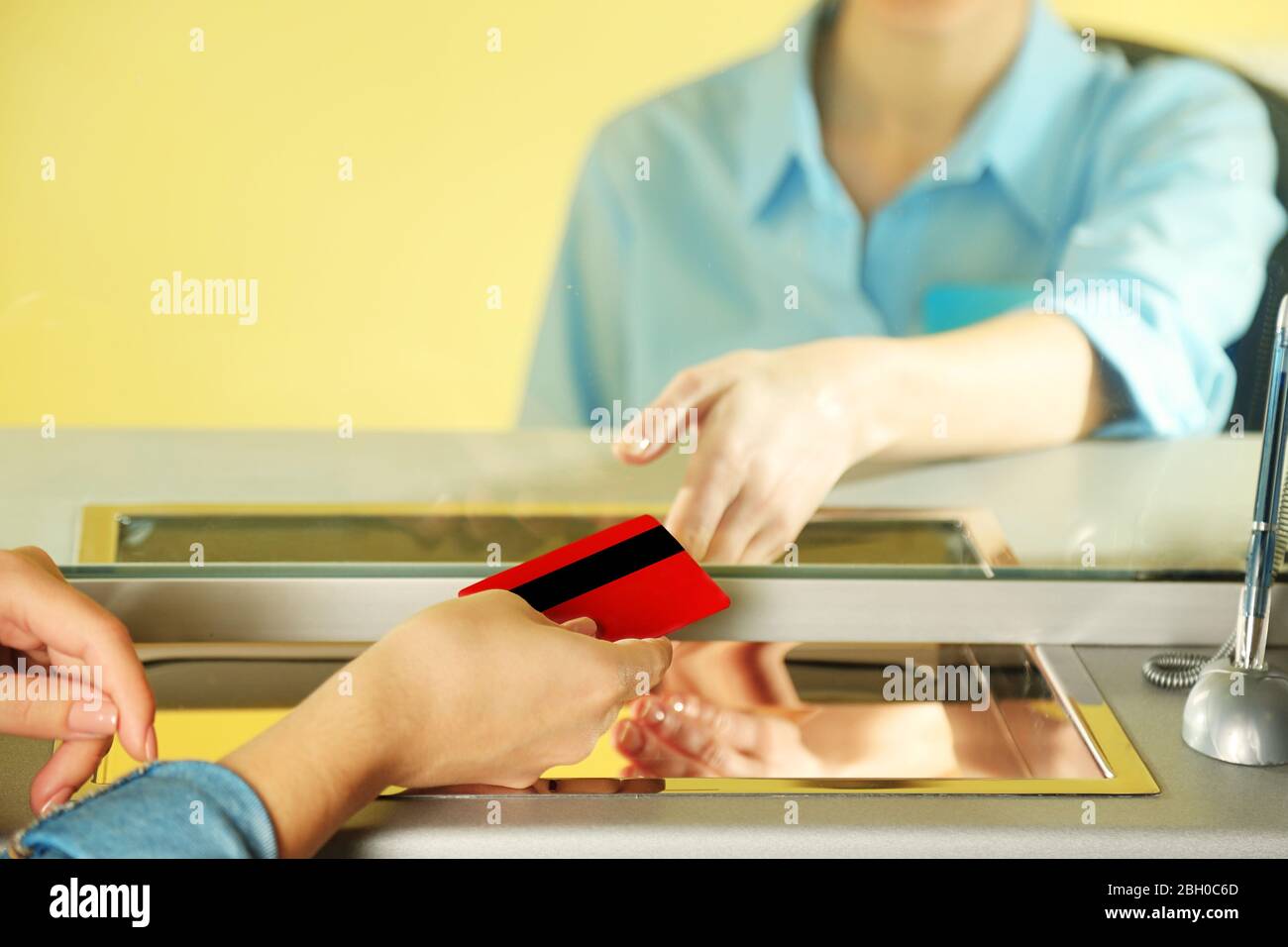 Teller window with working cashier Stock Photo - Alamy