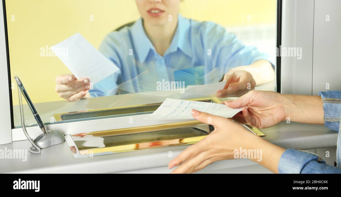 Teller window with working cashier Stock Photo - Alamy