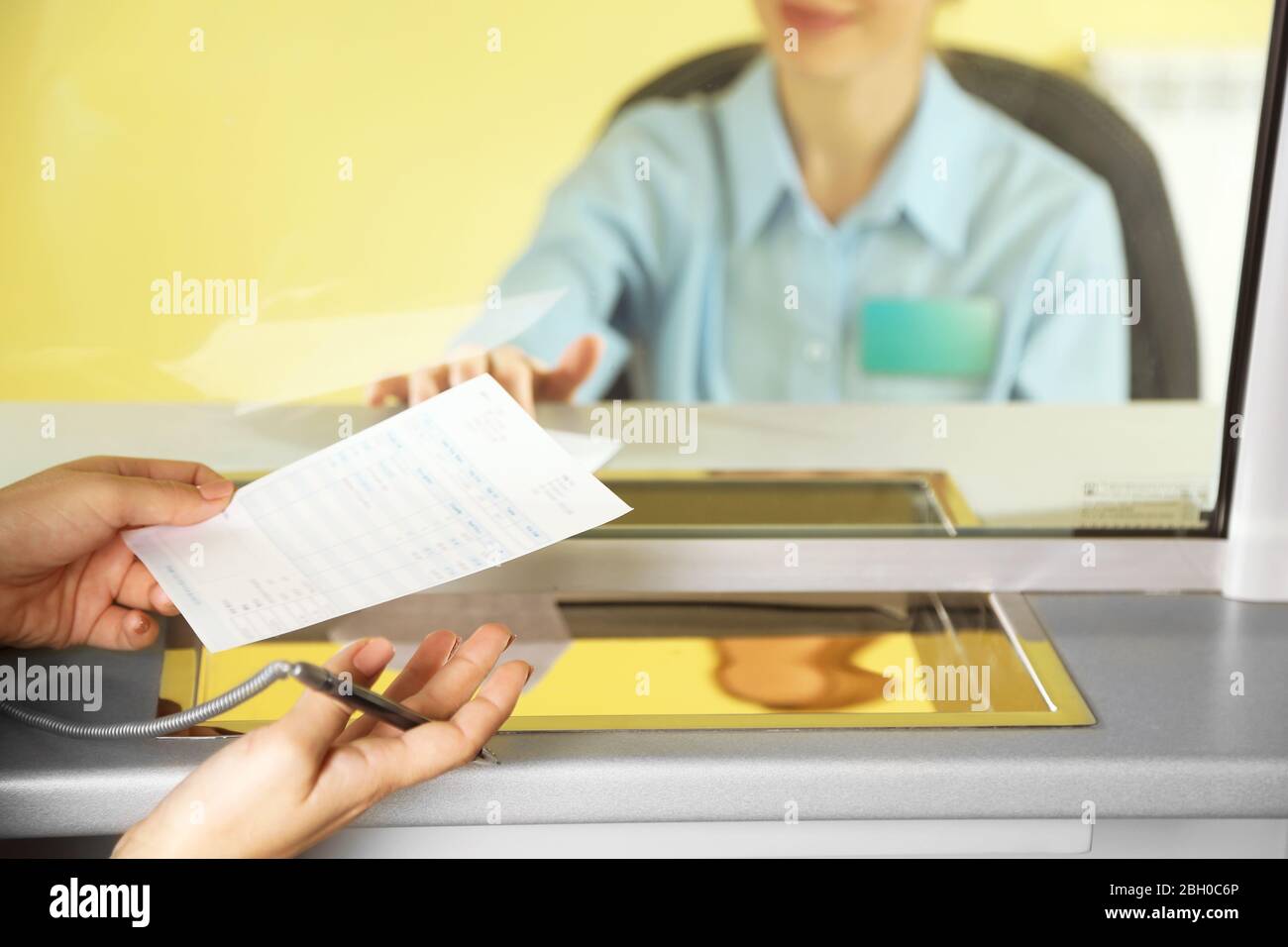 Teller window with working cashier Stock Photo - Alamy