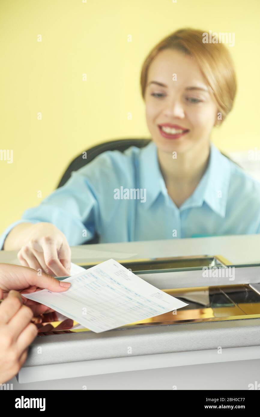 Teller window with working cashier Stock Photo - Alamy
