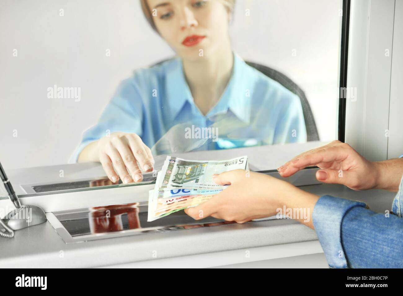 Teller window with working cashier Stock Photo - Alamy
