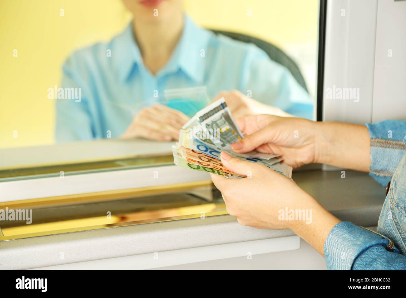 Teller window with working cashier Stock Photo - Alamy