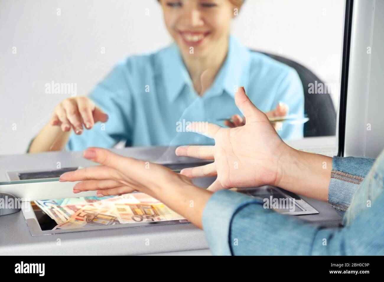 Teller window with working cashier Stock Photo - Alamy