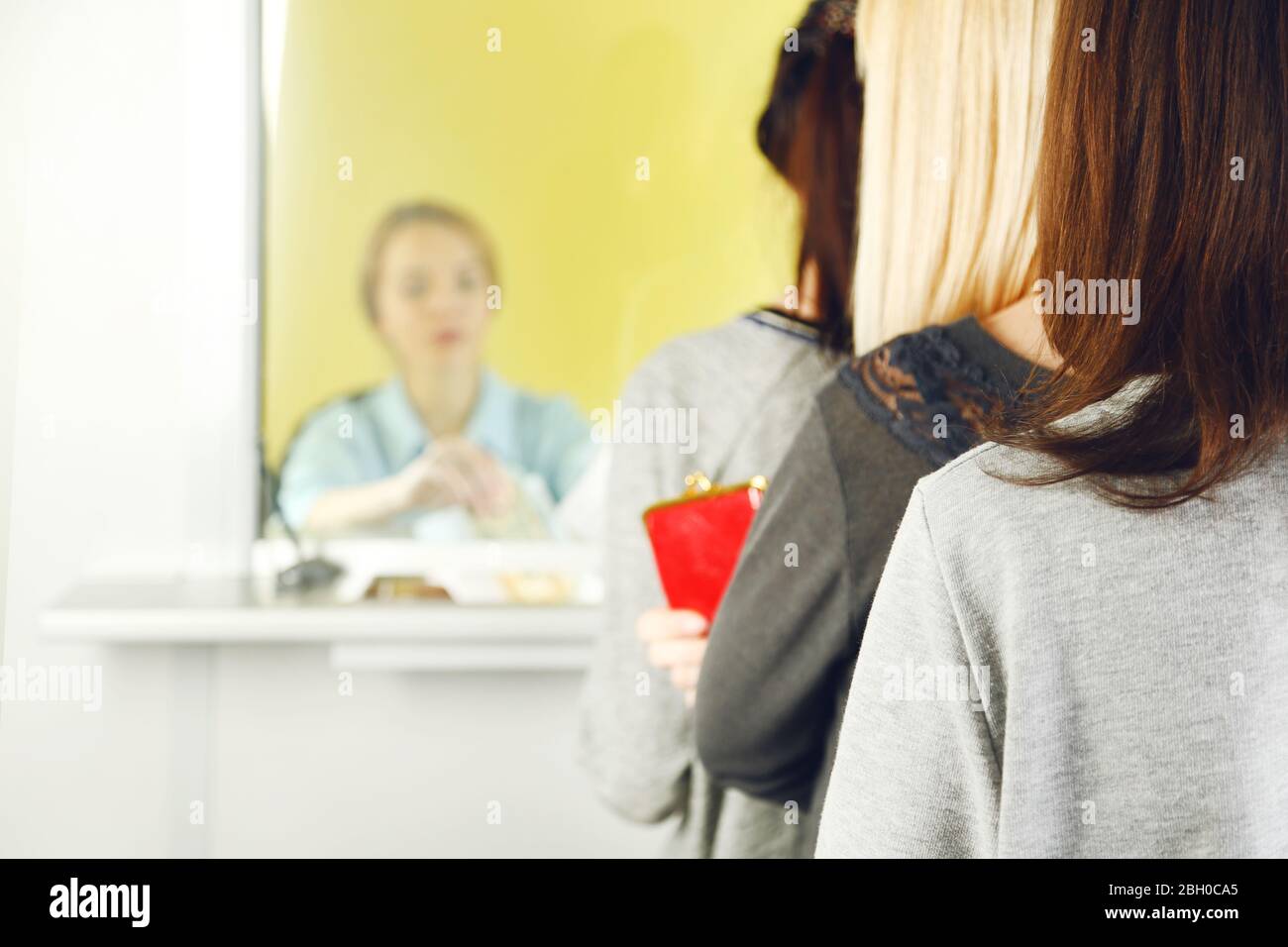 Teller window with working cashier Stock Photo - Alamy