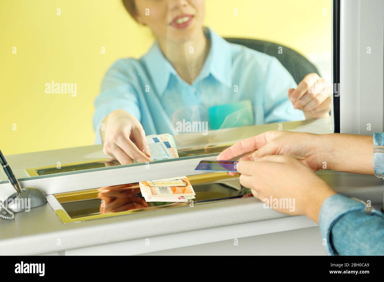 Teller window with working cashier Stock Photo - Alamy